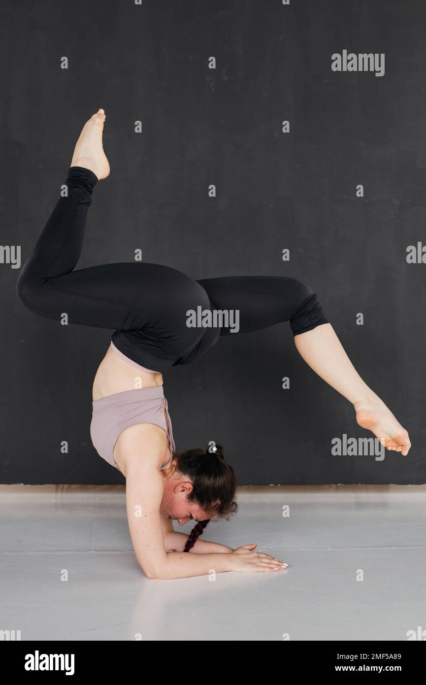 Young professional gymnast woman. Pretty brunette girl doing an elbow ...