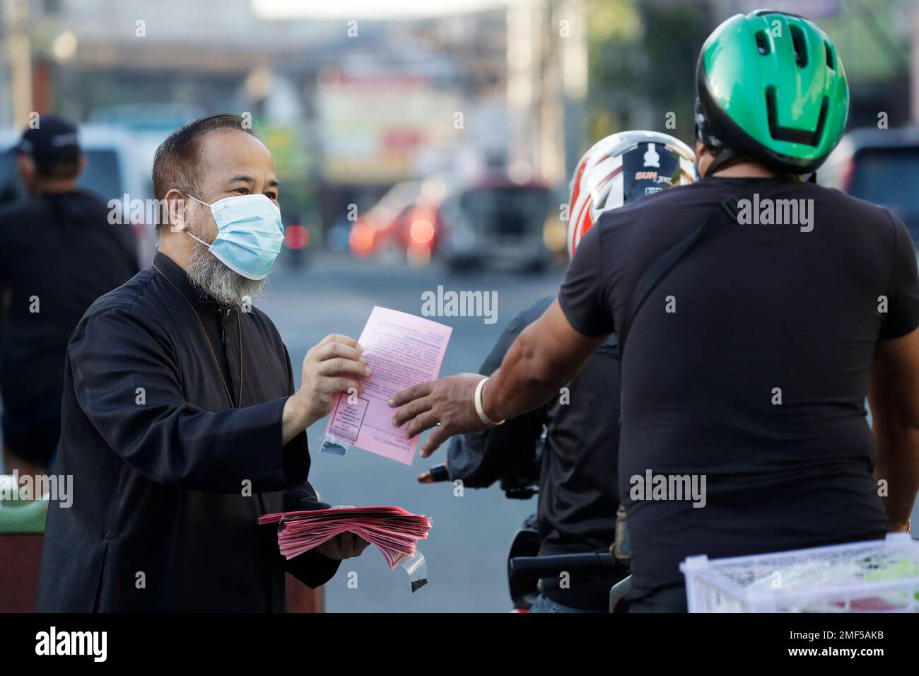 Catholic Priest Adrian Magnait, left, passes blessed ash placed in ...