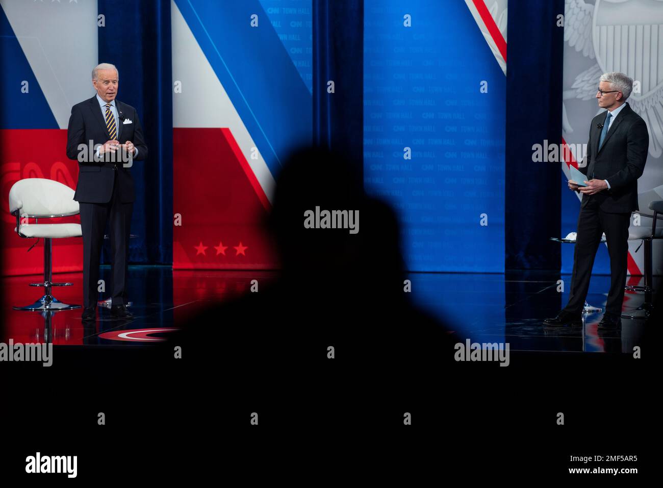 Anderson Cooper listens as President Joe Biden speaks during a ...