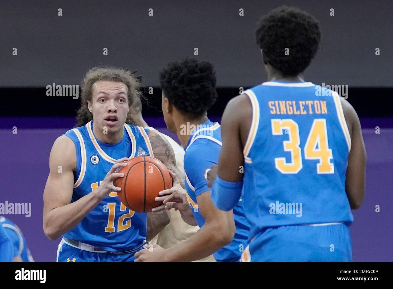 UCLA forward Mac Etienne, left, looks to pass to guard David Singleton ...