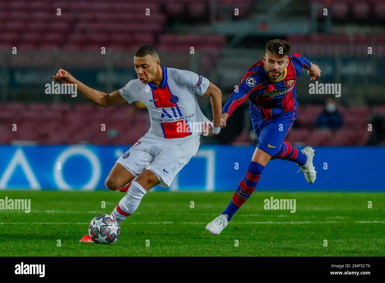 Barcelona's Gerard Pique, right, tries to stop PSG's Kylian Mbappe ...