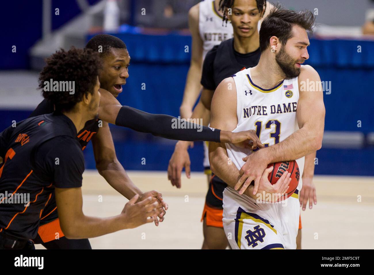 Miami's Anthony Walker, center, reaches for the ball as Notre Dame's ...