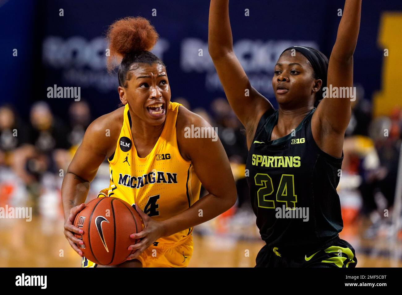 Michigan guard Akienreh Johnson (14) is defended by Michigan State ...