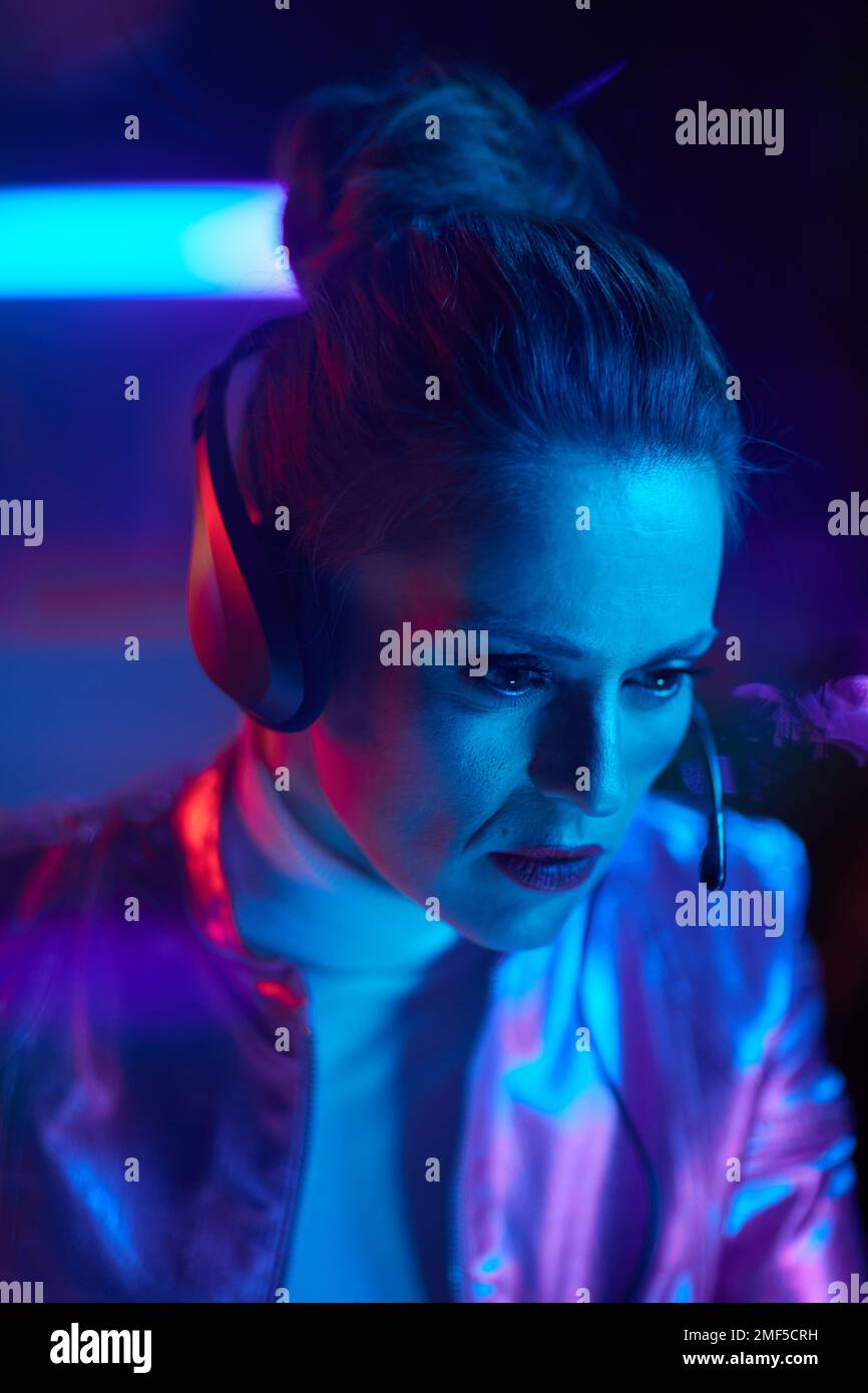 Neon metaverse futuristic concept. pensive trendy 40 years old woman ...