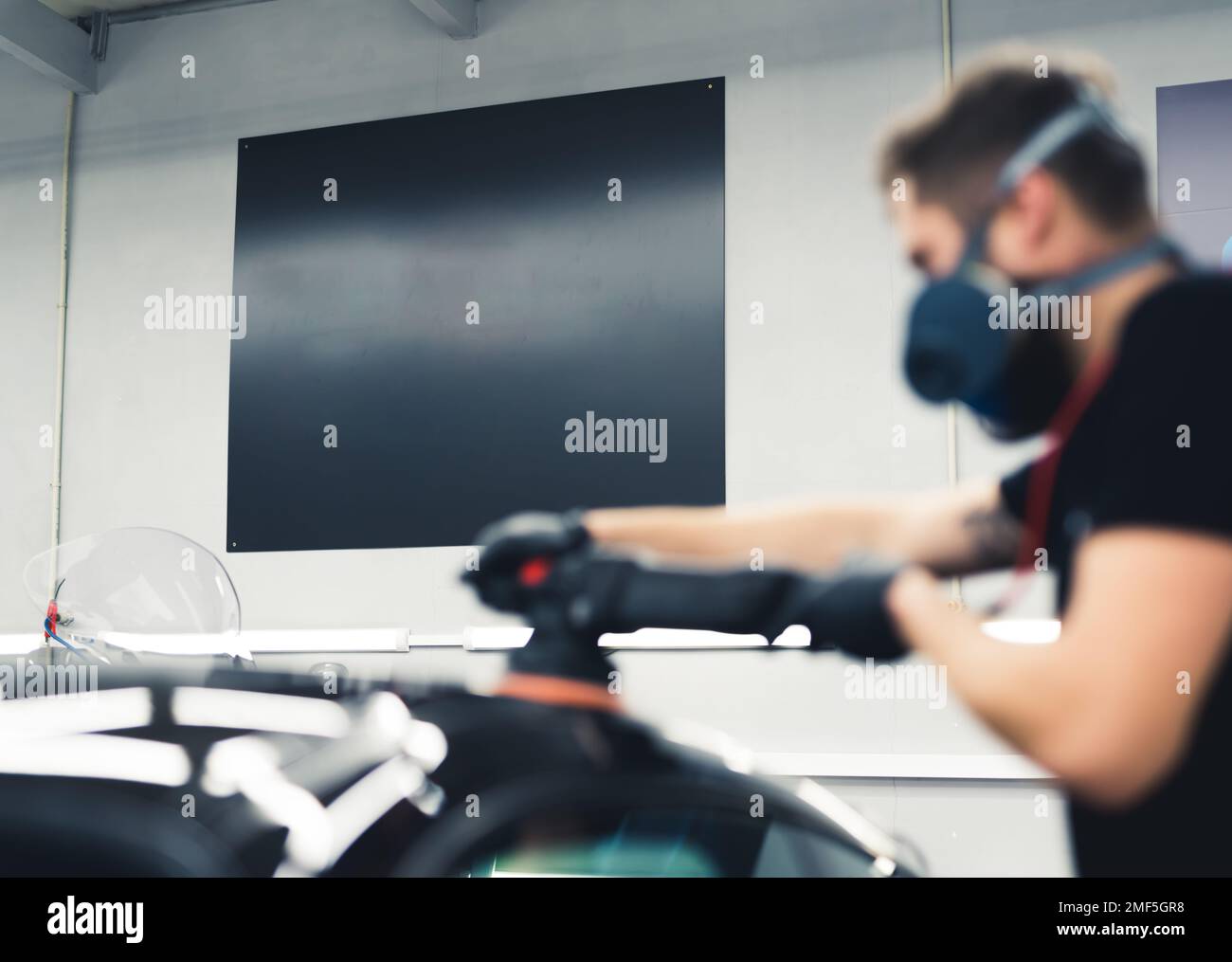 White man wearing protective face mask using professional tool to ...