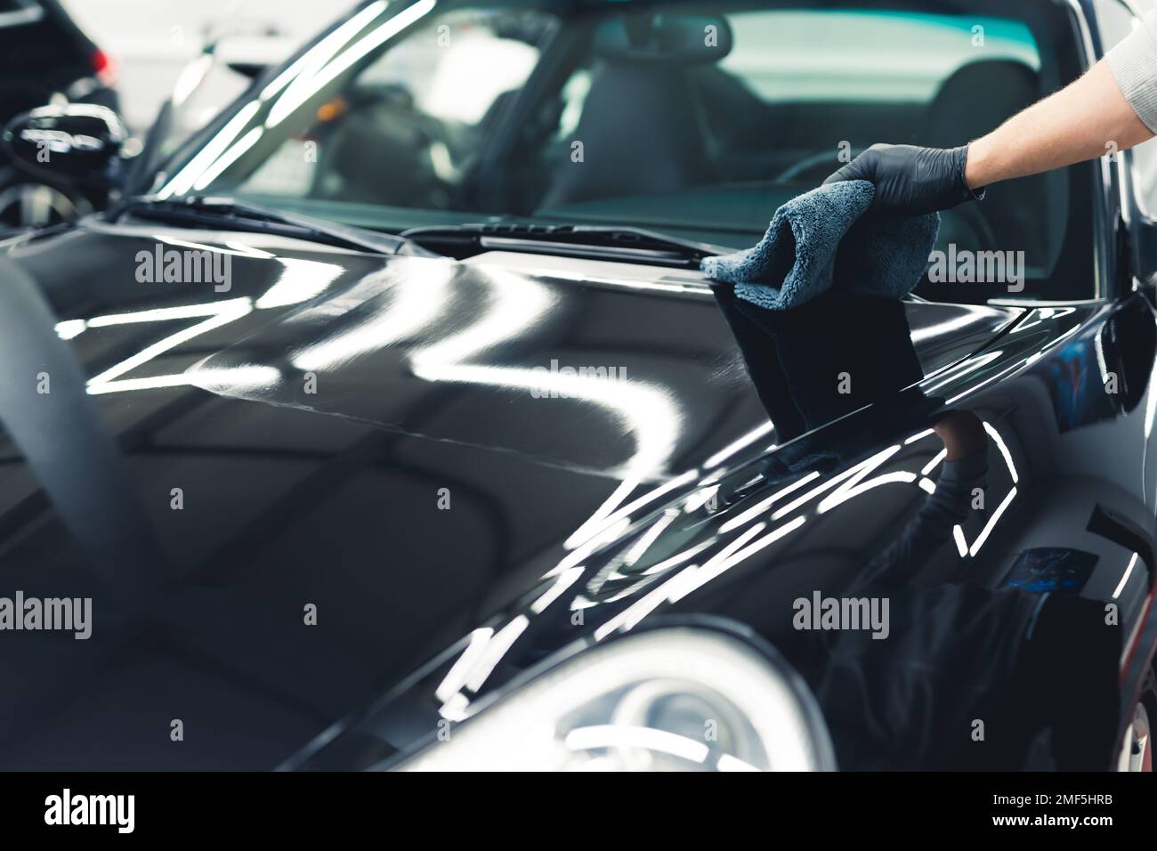 Unrecognisable man wearing black gloves applying ceramic coating to the ...