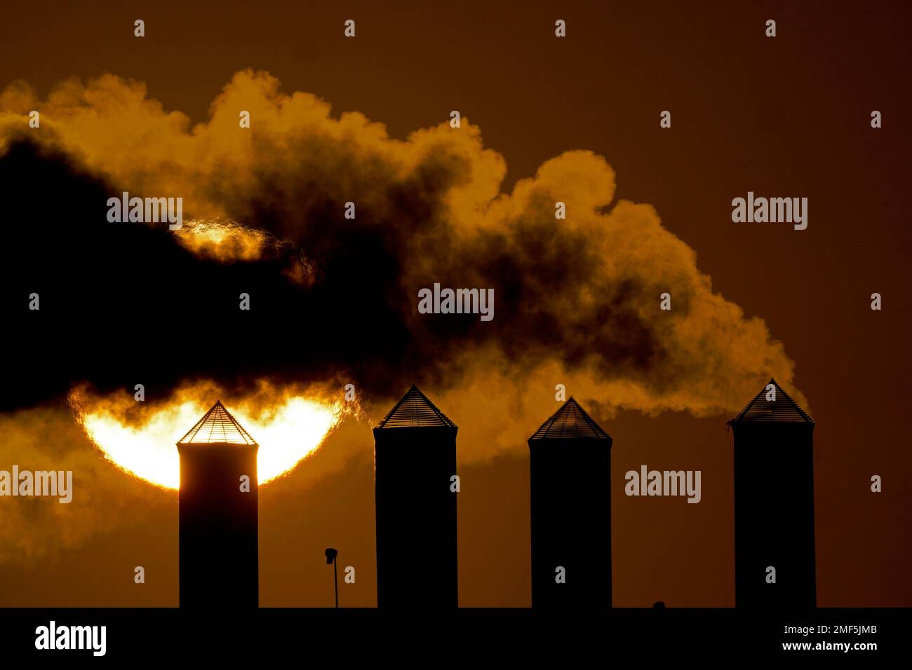 The sun sets beyond a plant that processes corn into various ...