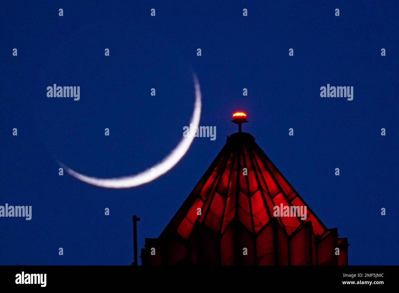 The crescent moon sets beyond THE Art Deco spire on an apartment ...