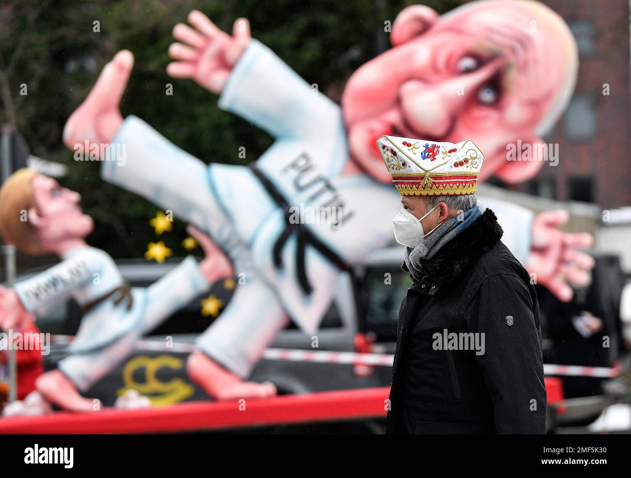 A reveller stands in front of a political carnival float depicting ...