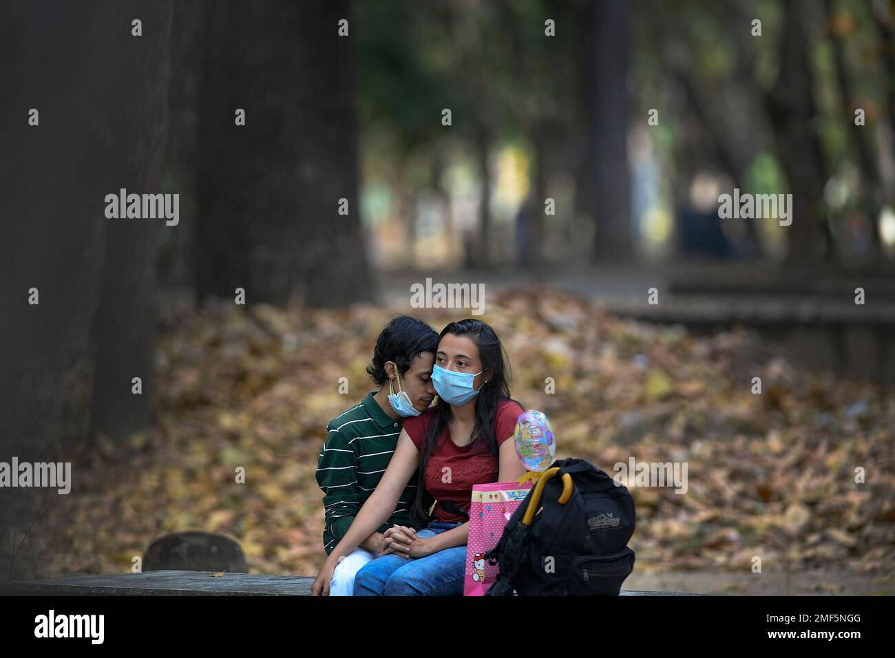 A couple wearing masks curb the spread of the new coronavirus sit ...