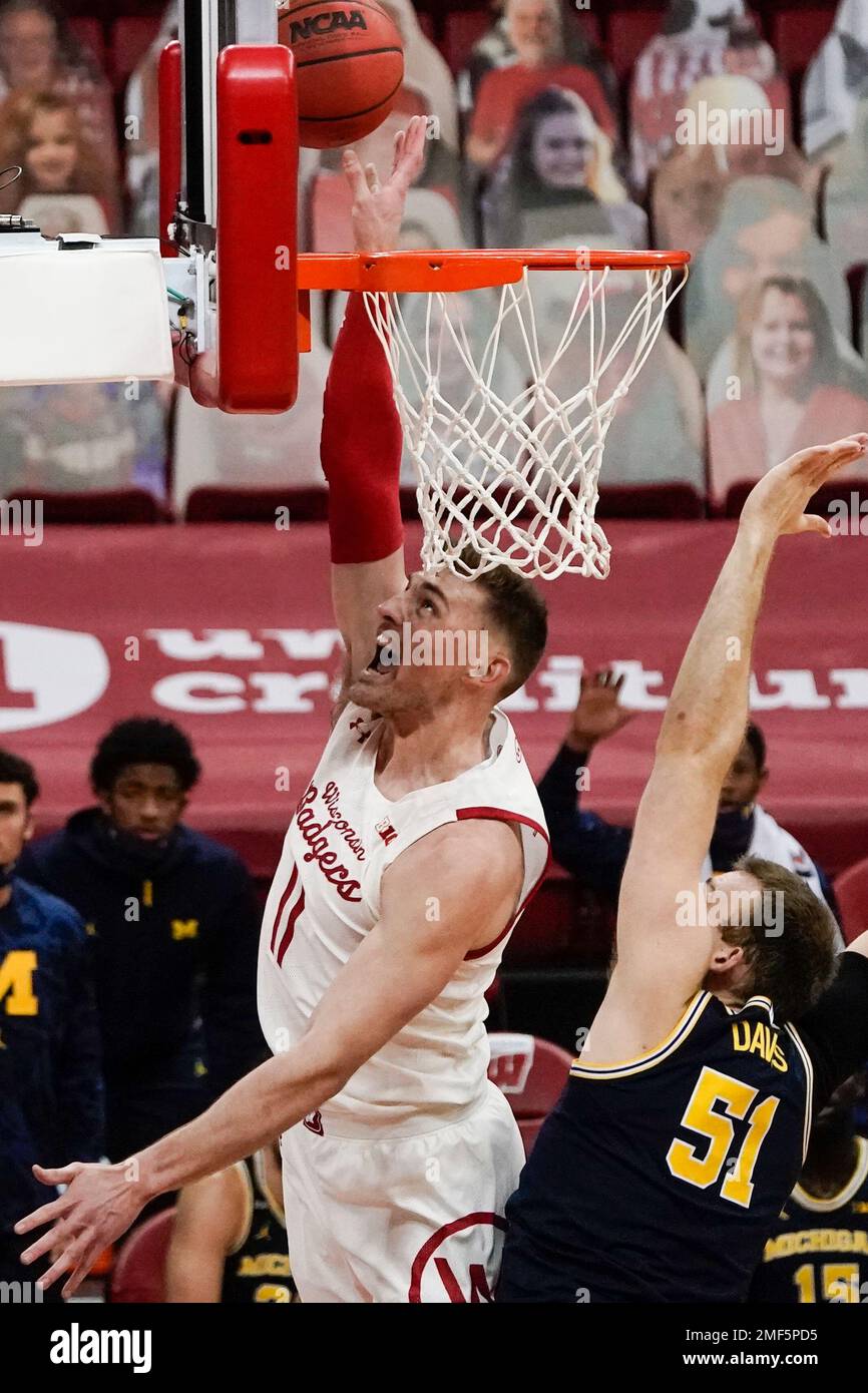 Wisconsin's Micah Potter shoots past Michigan's Austin Davis during the ...