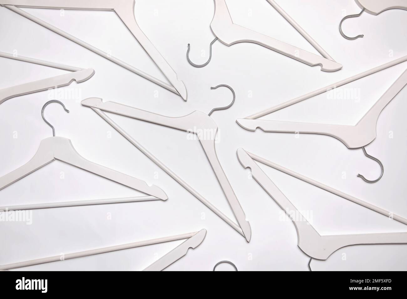 Pattern of empty white hangers flat lay on white background. Abstract ...