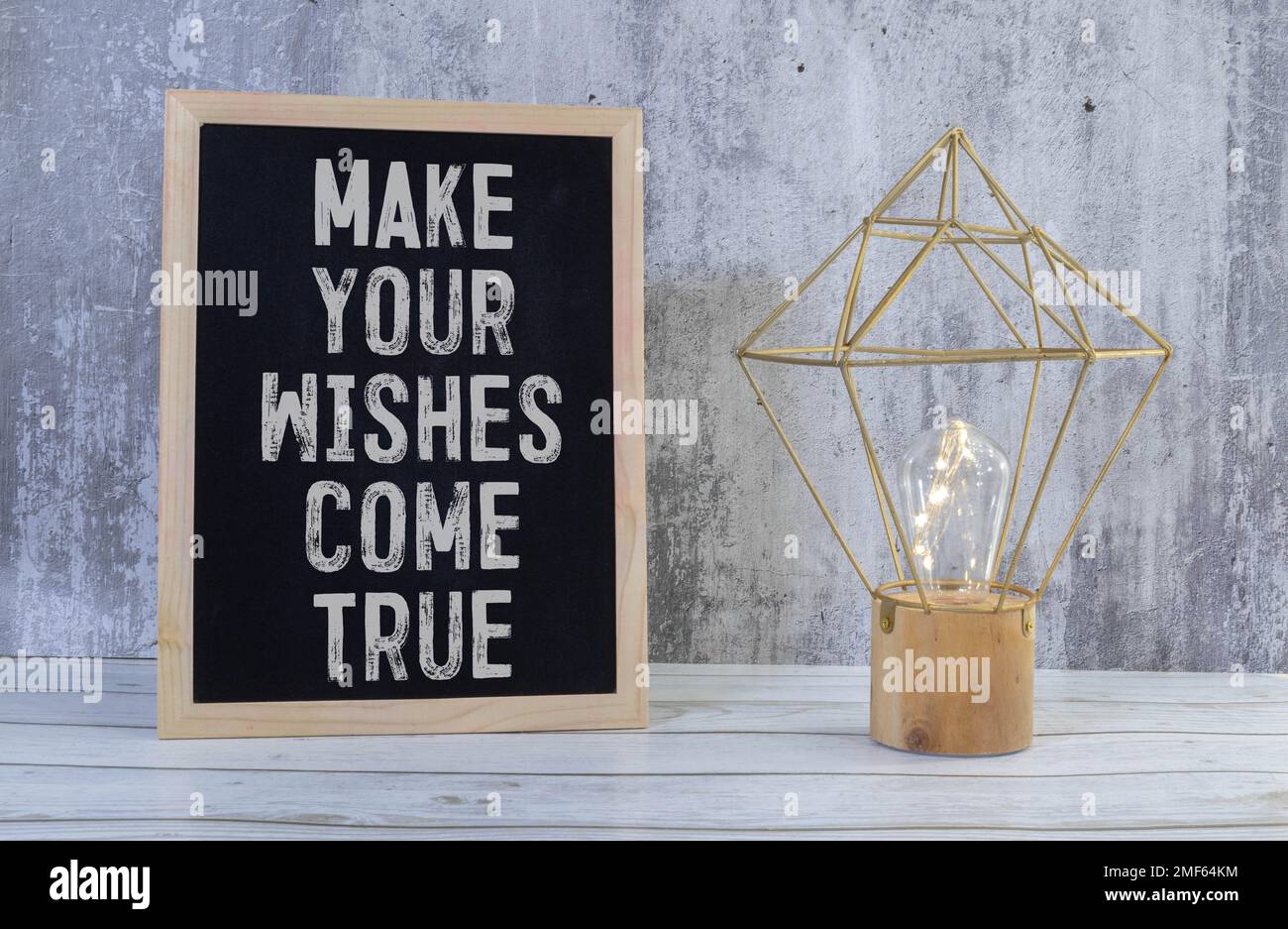 White notebook with inscription MAKE YOUR WISHES COME TRUE written in ...