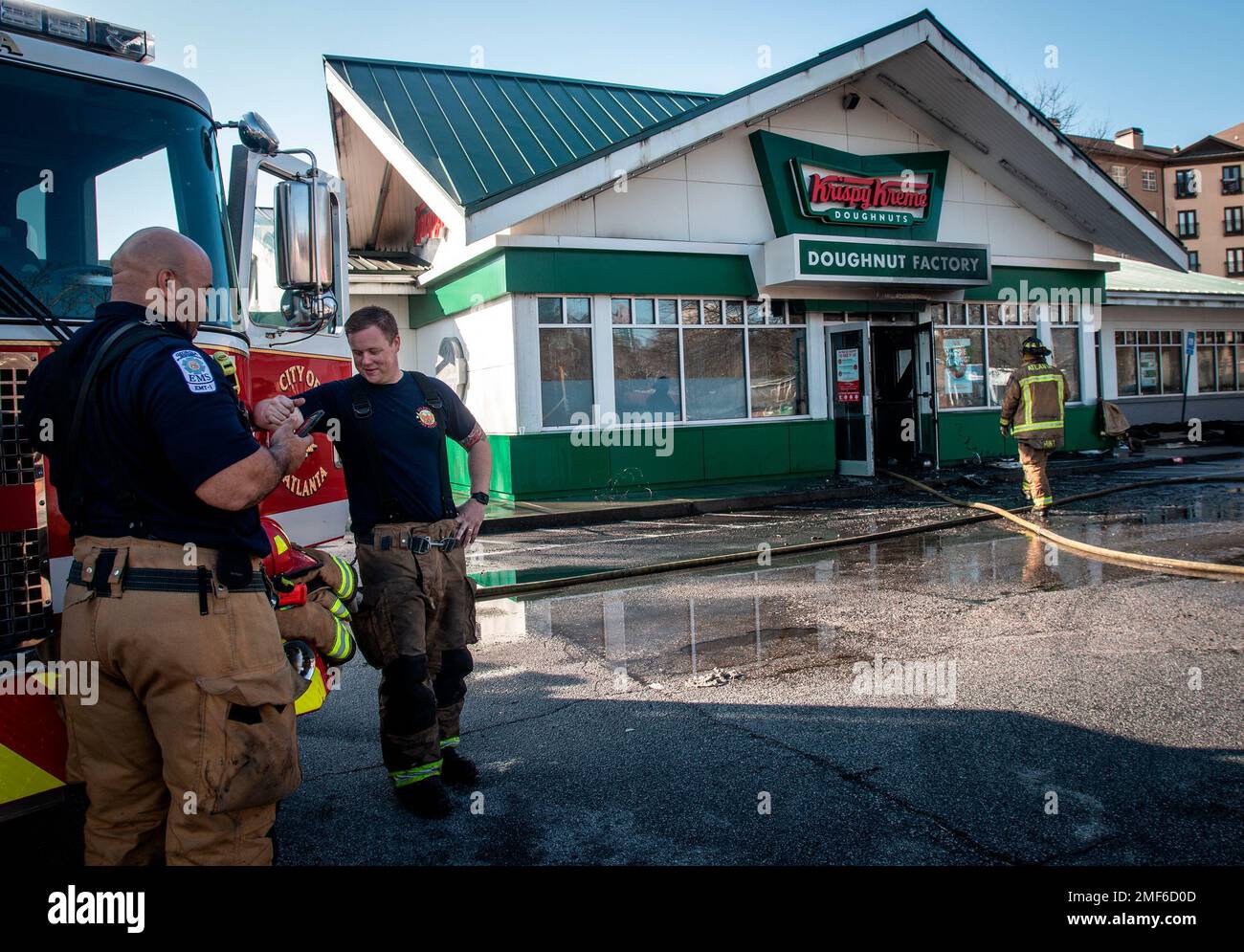 Firefighters talk in front of a burned Krispy Kreme Doughnuts store in ...