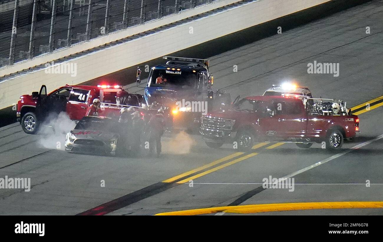Rescue workers help Cole Custer (41) after his car caught on fire ...