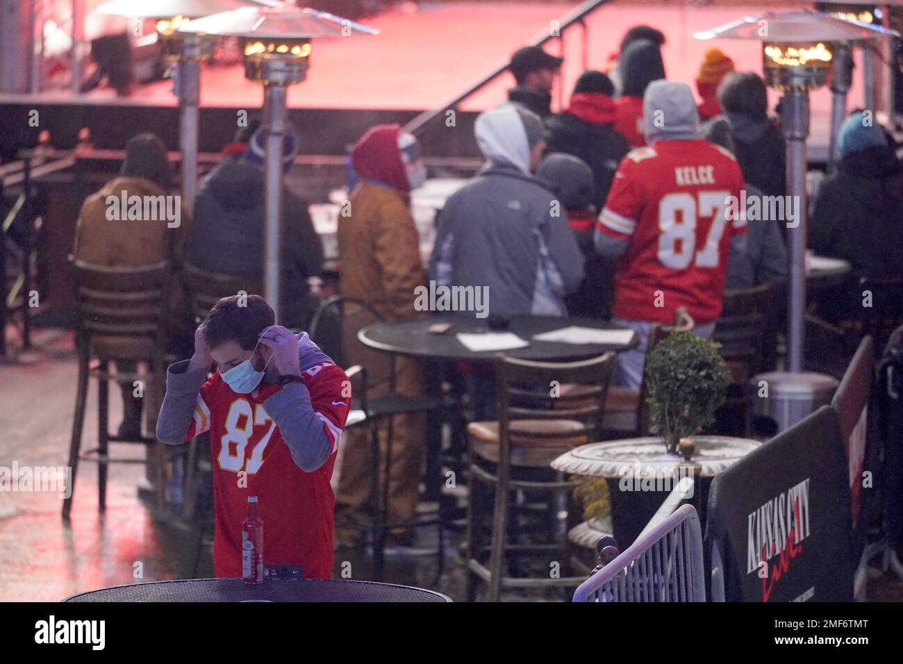 A Kansas City Chiefs fan replaces his mask while watching the Super ...