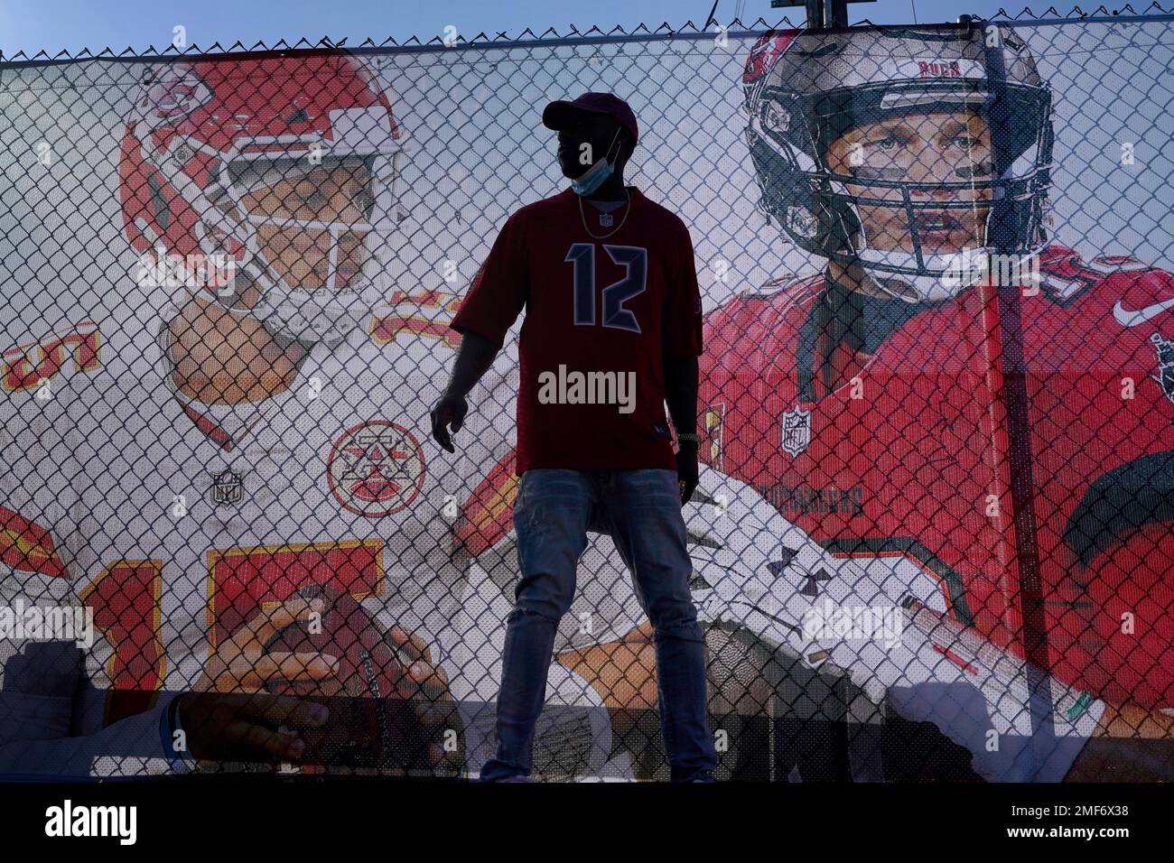 Cornelius Bardney of Chicago, Ill., walks by a fence with cover that ...