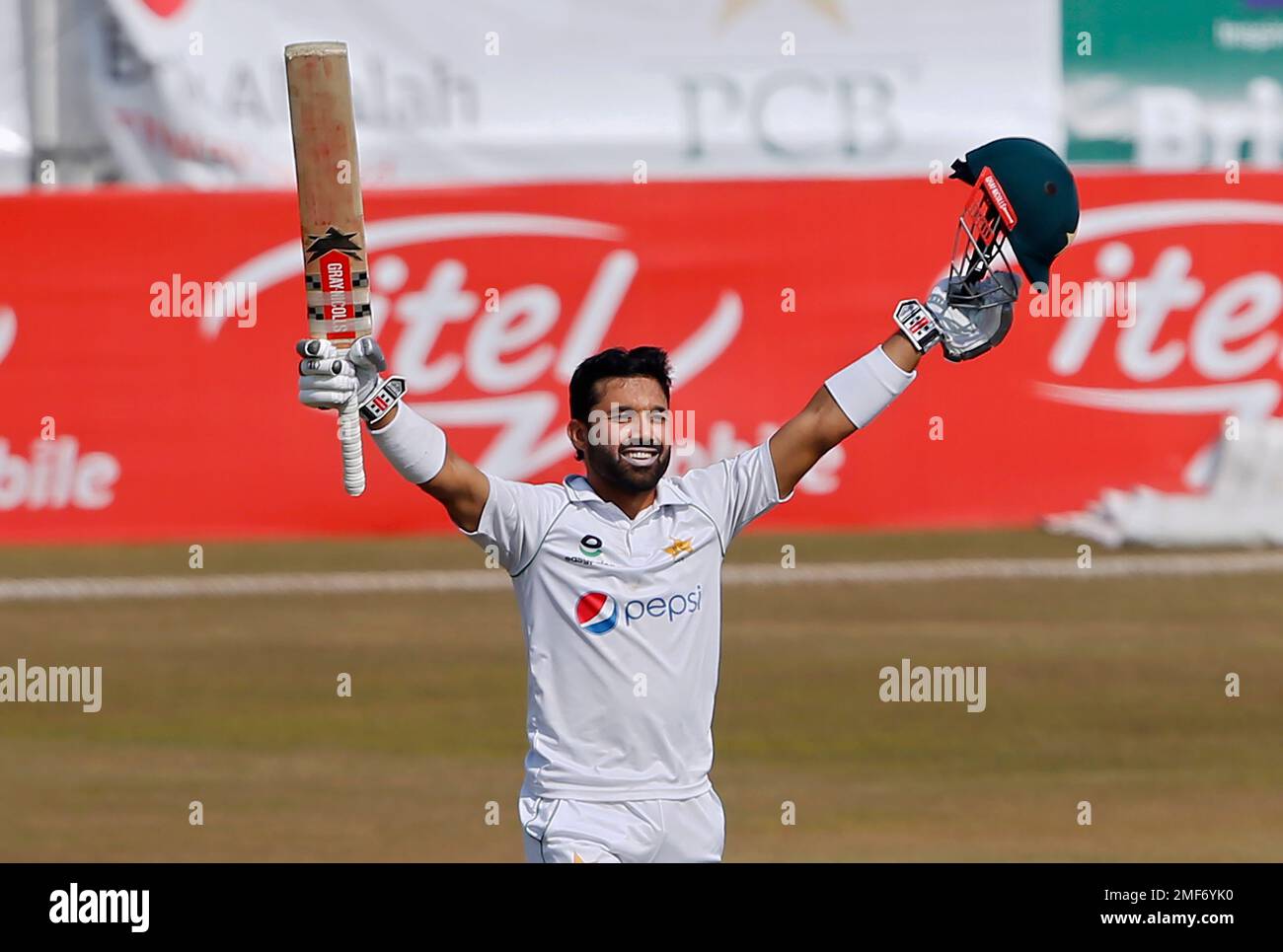 Pakistan's Mohammad Rizwan raises bat and helmet to celebrate after ...