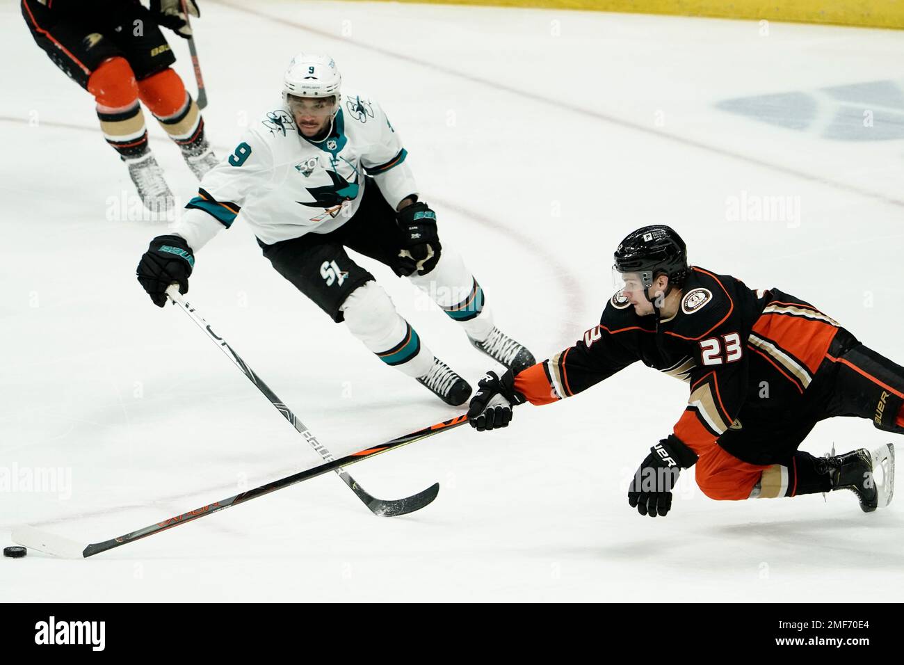 Anaheim Ducks' Sam Steel, right, reaches for the puck next to San Jose ...