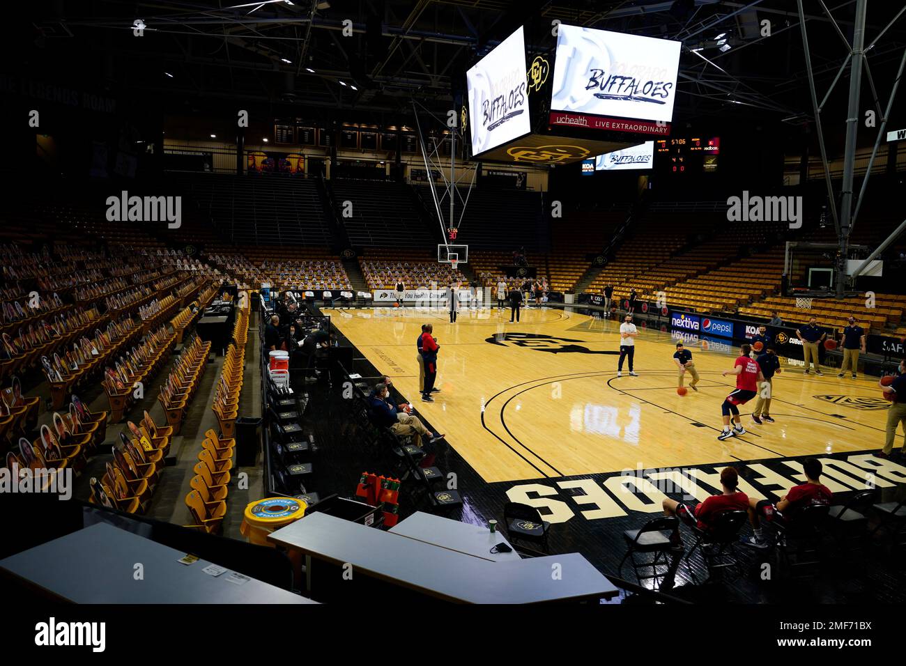 Arizona and Colorado players warm up in an empty arena for an NCAA ...