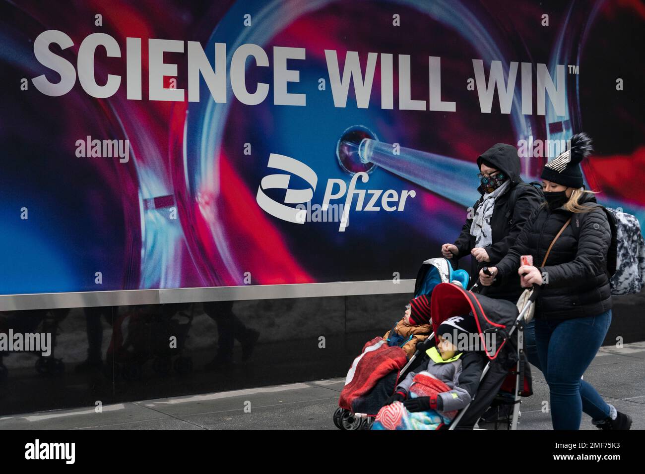 Women walk by Pfizer headquarters, Friday, Feb. 5, 2021 in New York ...