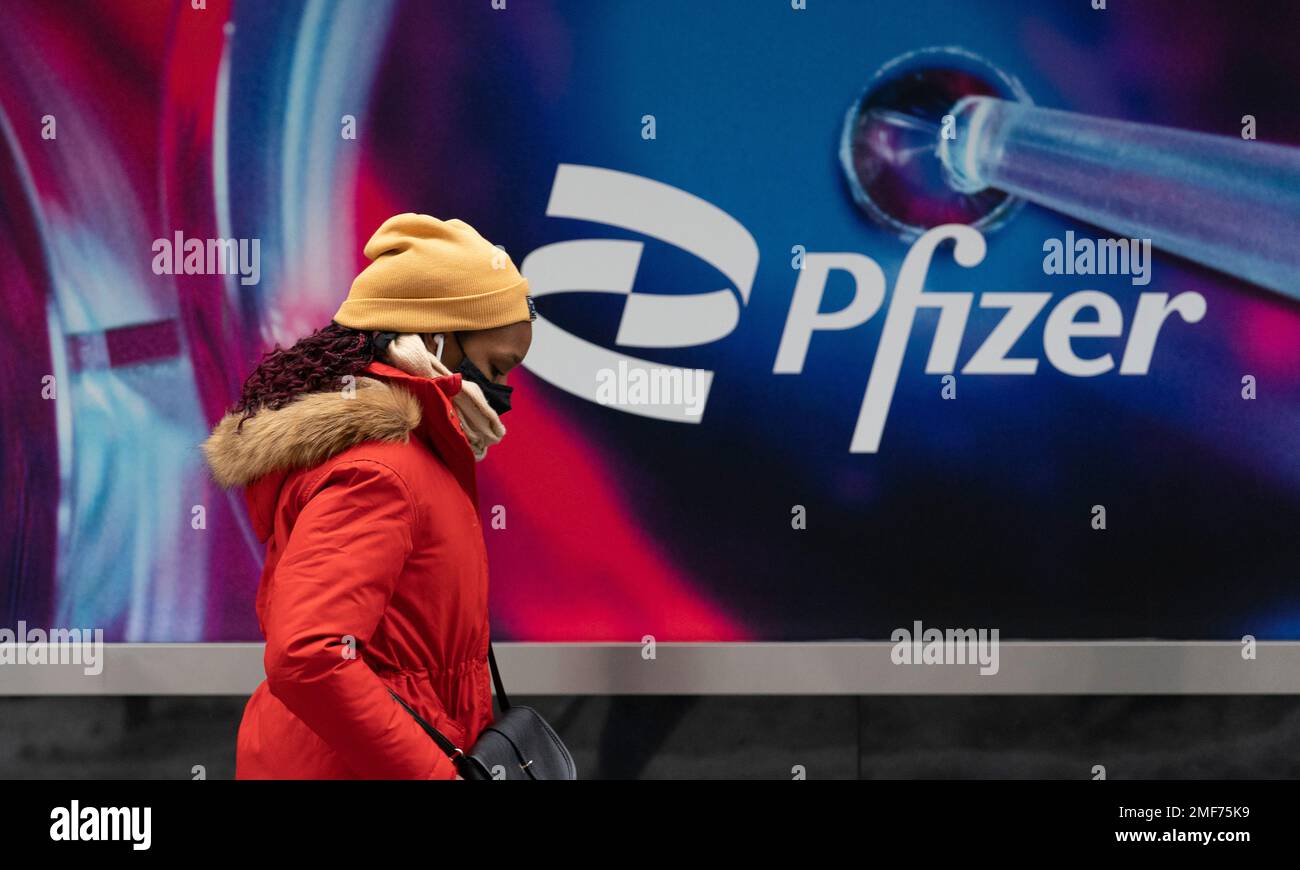 A woman walks by Pfizer headquarters, Friday, Feb. 5, 2021 in New York ...