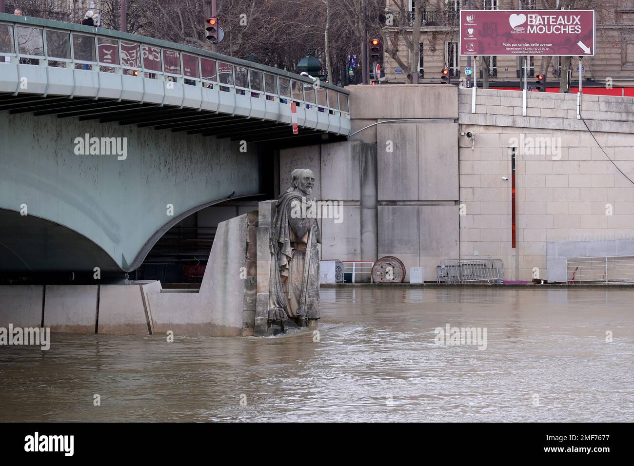 People walk onto the Alma bridge as the feet of the Zouave statue ...