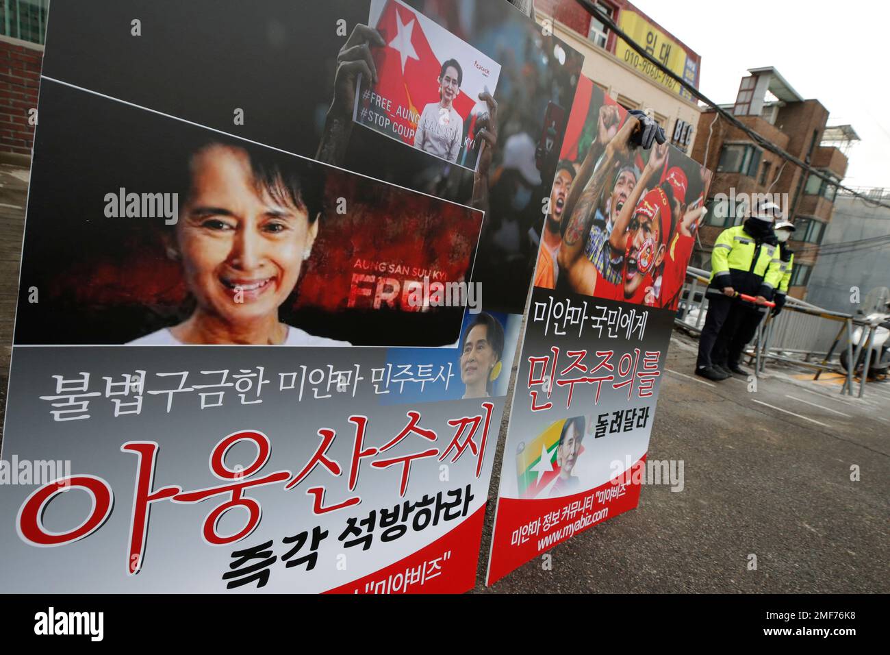 A man holds banners carrying the pictures of Myanmar leader Aung San ...