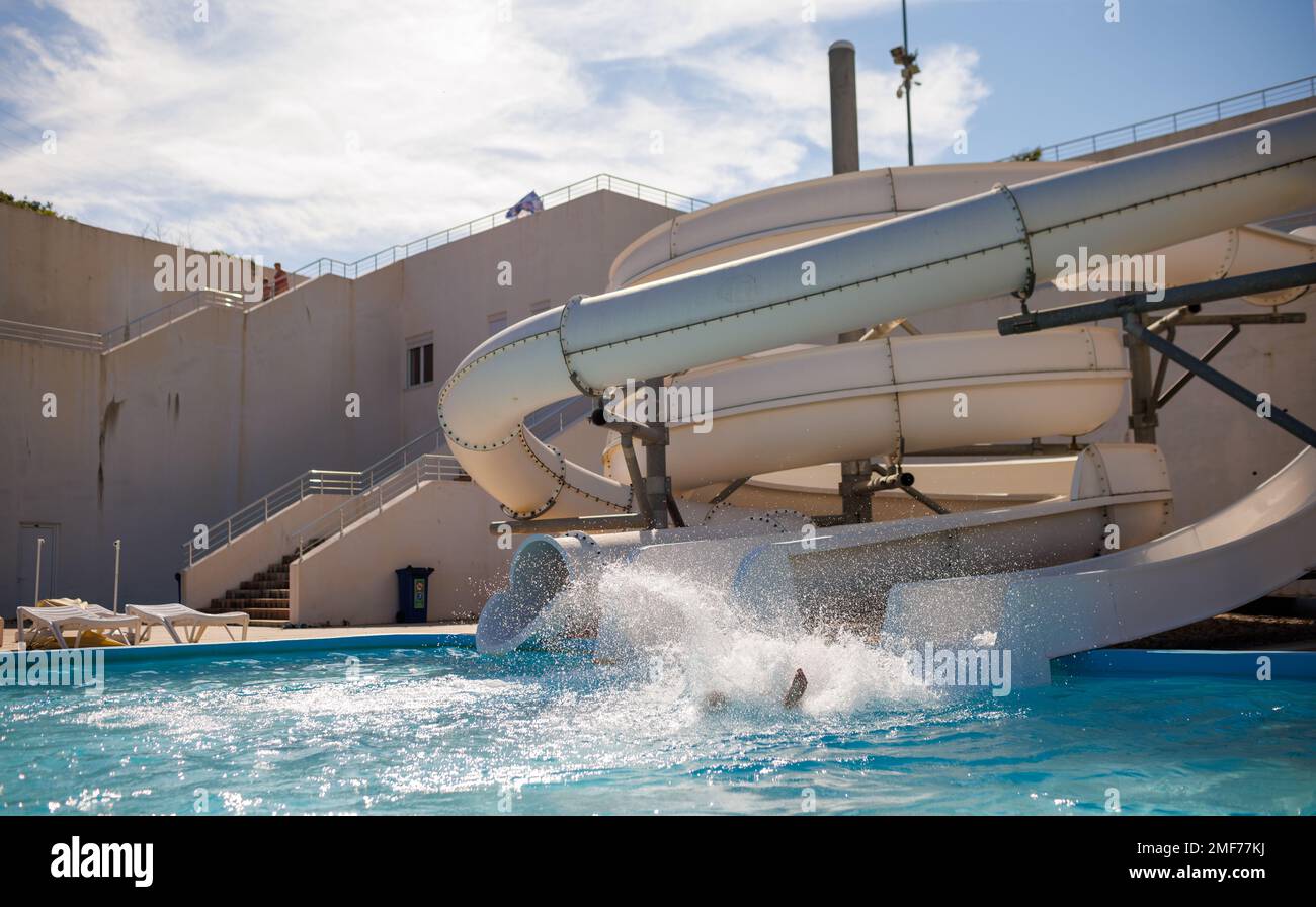 Someone unknown descends from a high white extreme slide into a ...