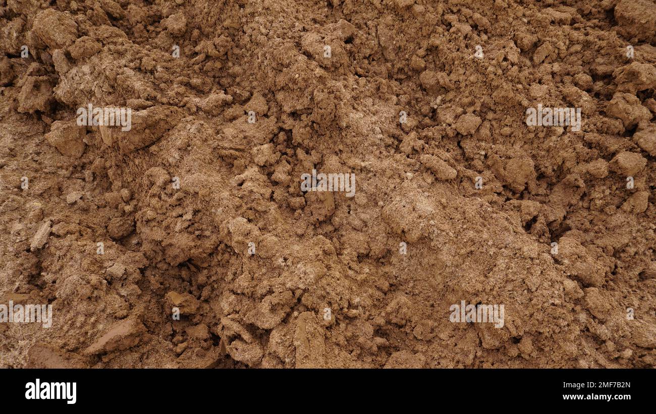 Closeup of macro view of red dirt or mud of pile soil from agriculture ...