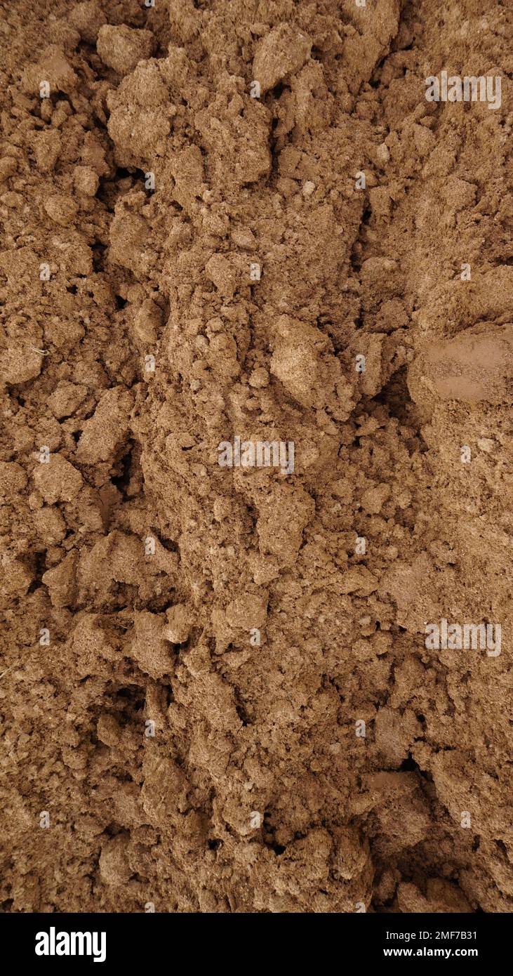 Closeup of macro view of red dirt or mud of pile soil from agriculture ...