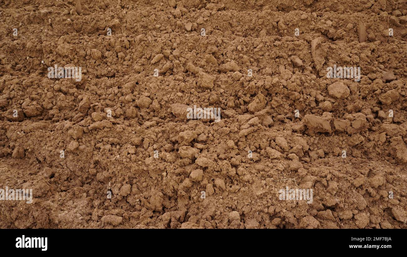 Closeup of macro view of red dirt or mud of pile soil from agriculture ...