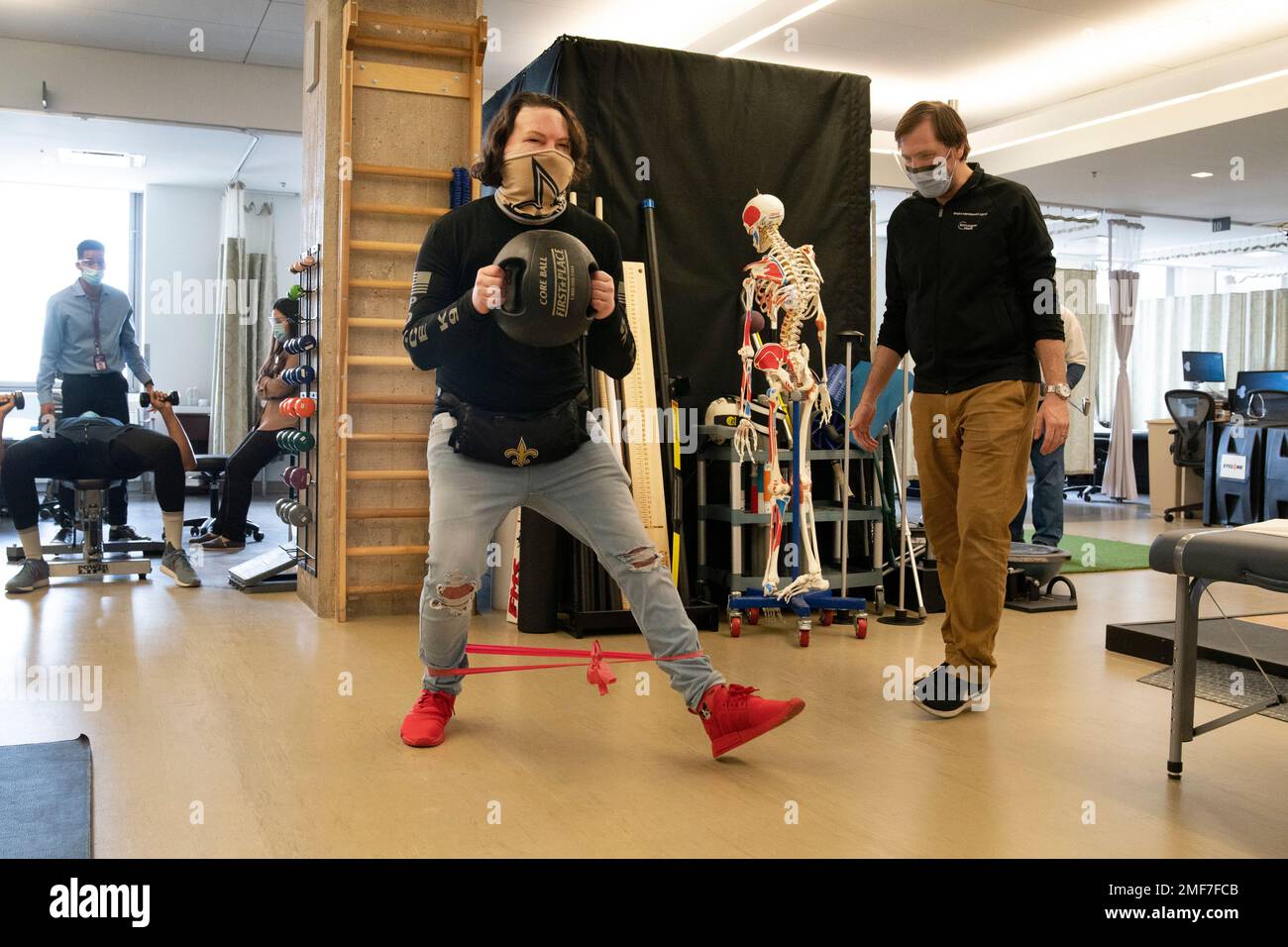 Physical therapist Eric Ross, right, watches as Joe DiMeo exercises ...