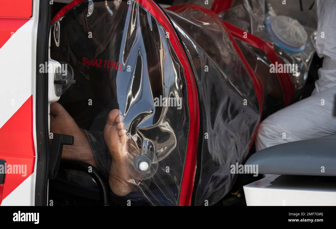 Paramedics in hazmat suits move a COVID-19 patient inside a ...