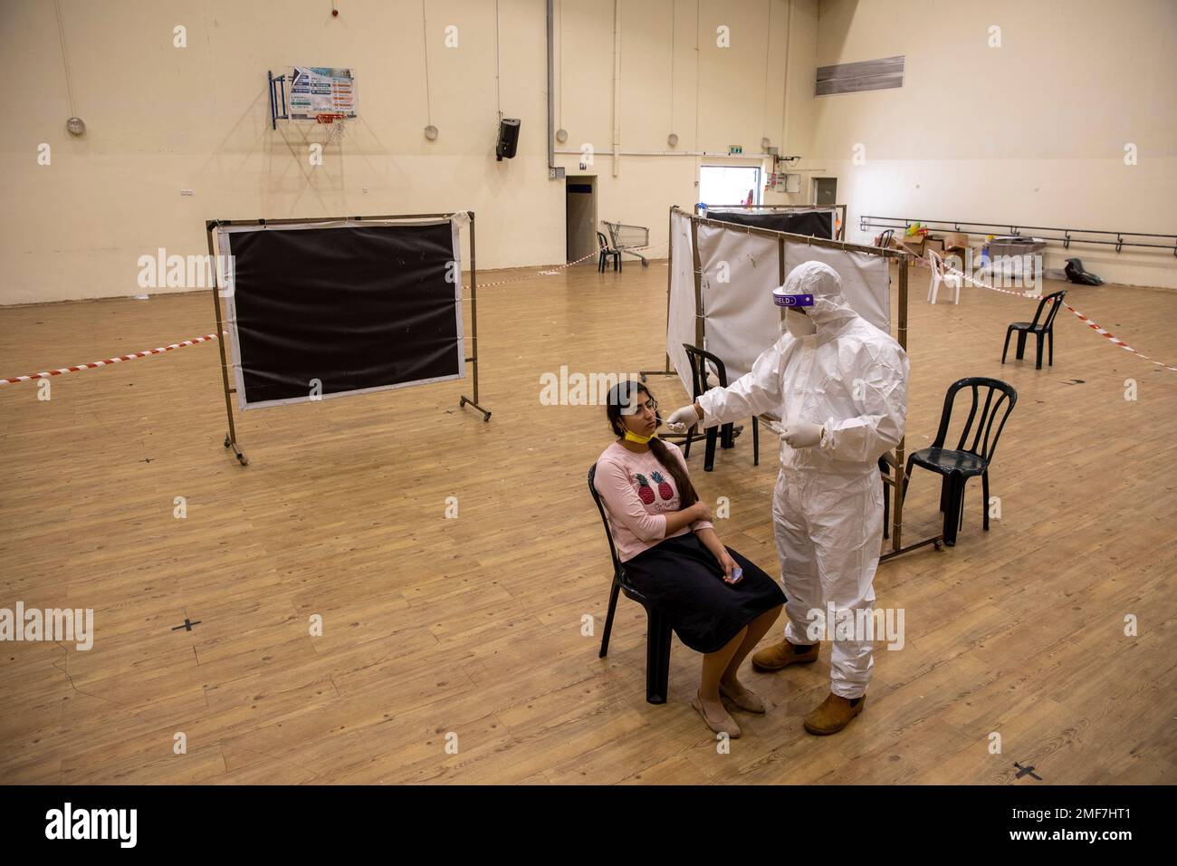 A medical professional tests a woman for coronavirus in Elad, Israel ...