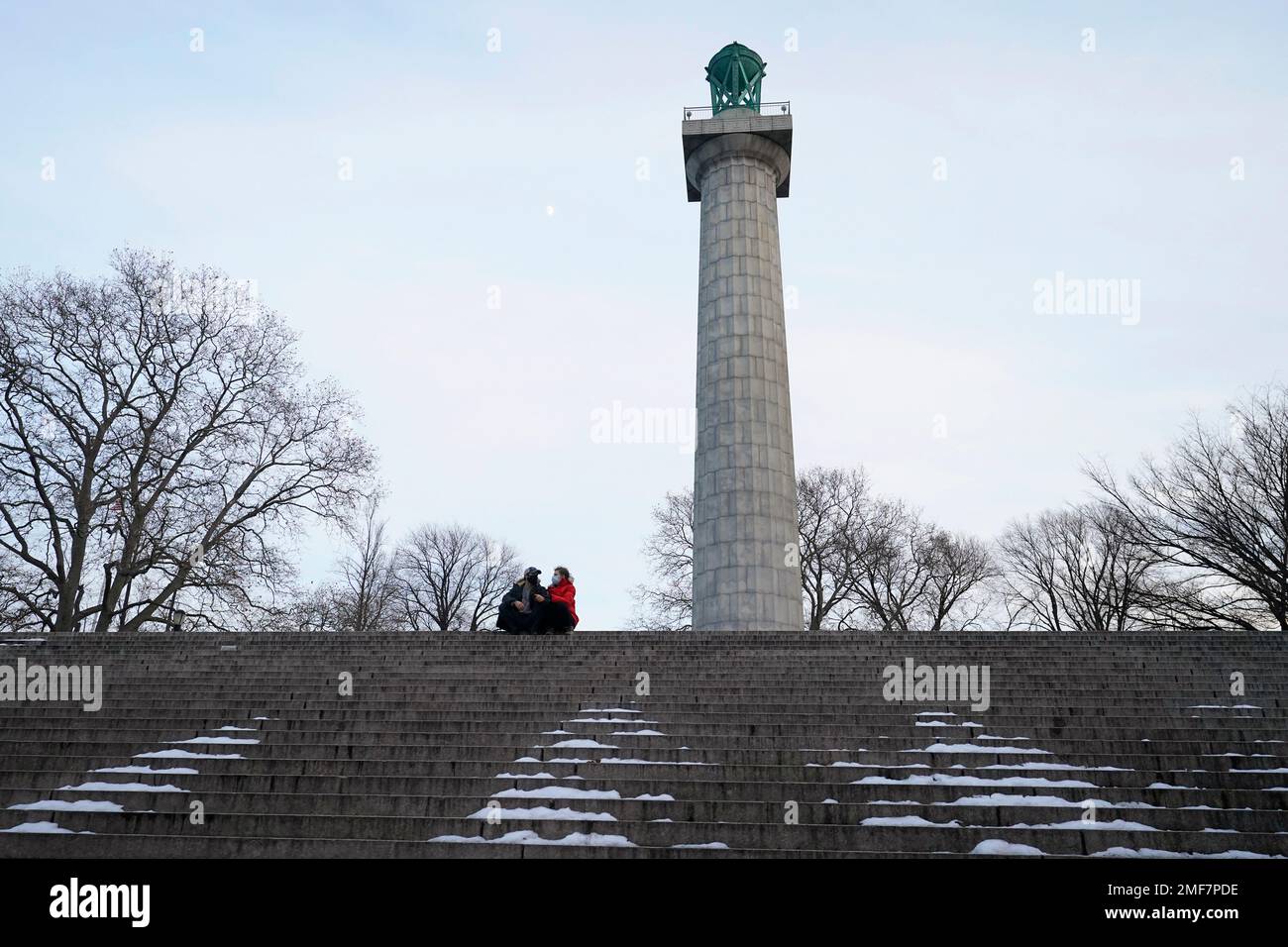 A couple sits on the steps of Fort Greene Park's Monument Plaza at dusk ...