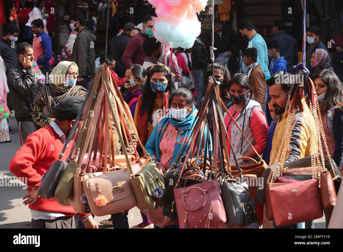 Indians wearing face masks as a precaution against the coronavirus walk ...