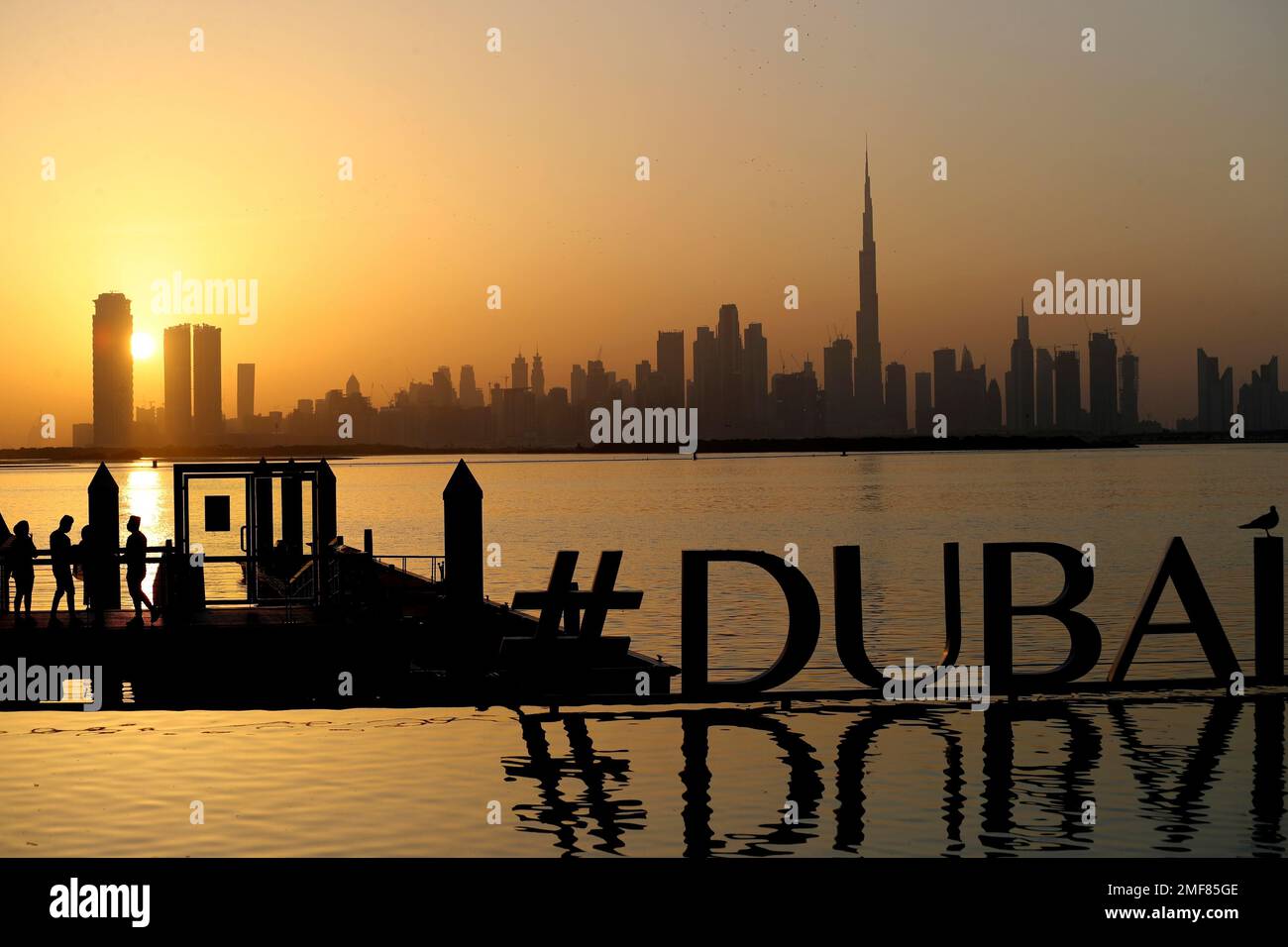 People enjoy the sunset with the view of city skyline and the world ...