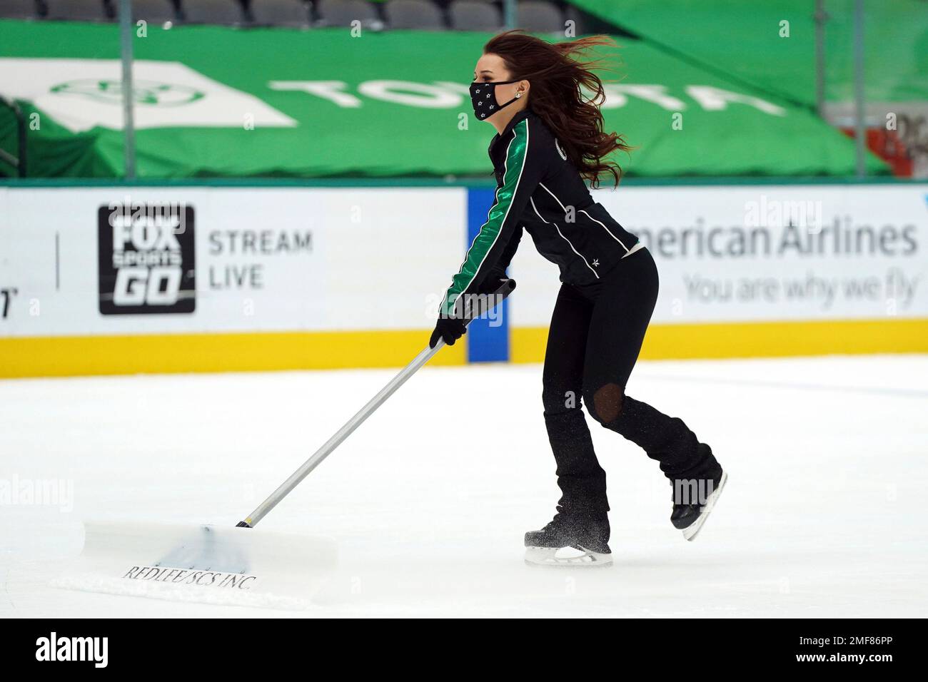 A Dallas Stars Ice Girl clears the ice during an NHL hockey game ...