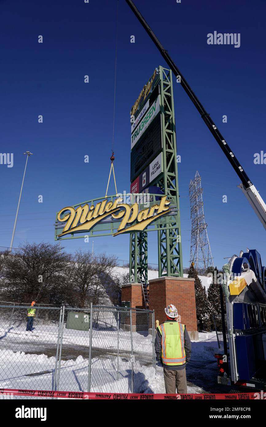 Workers remove a Miller Park sign before replacing it with an American ...