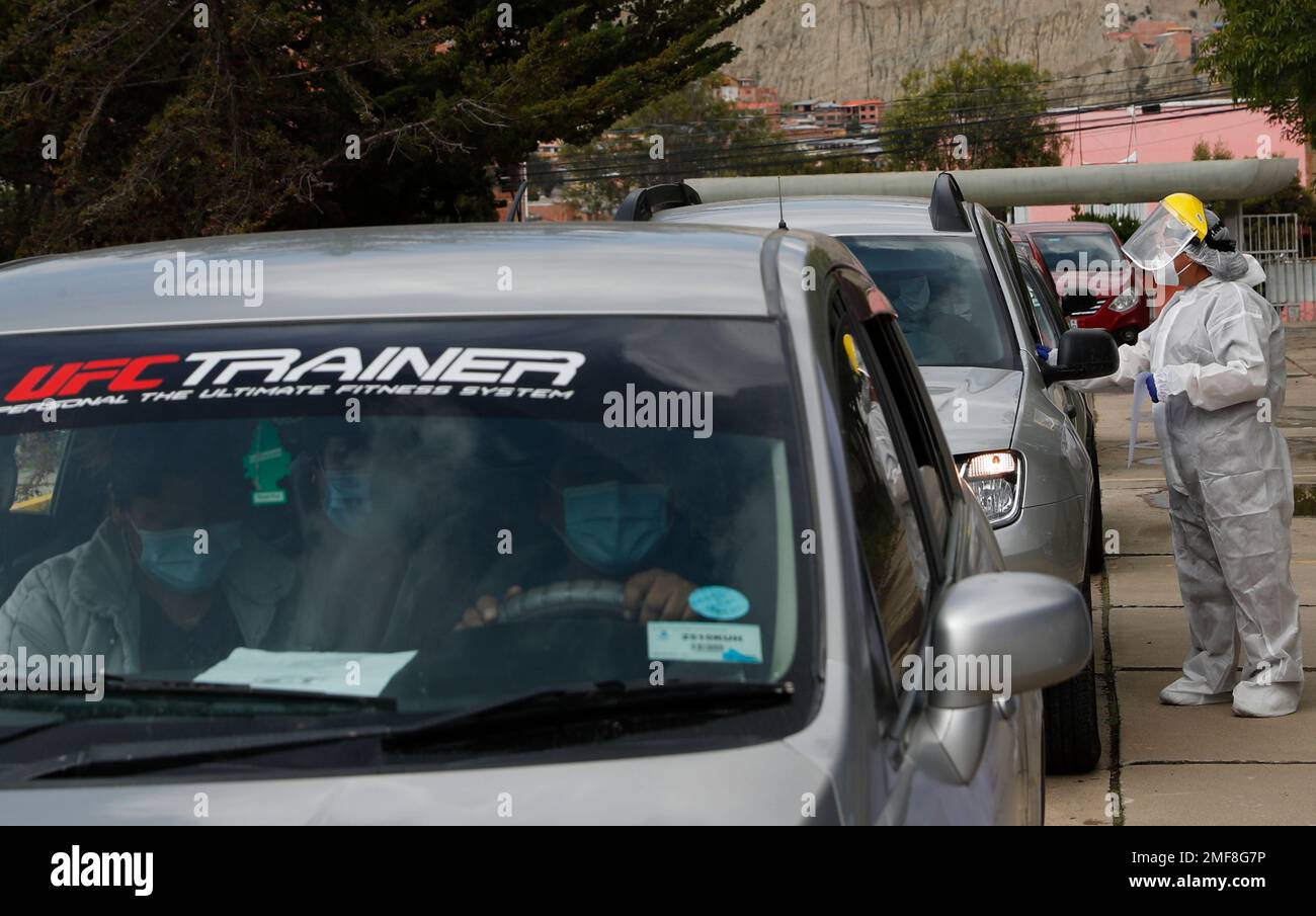 A health worker speaks with a driver at a COVID-19 testing site at the ...