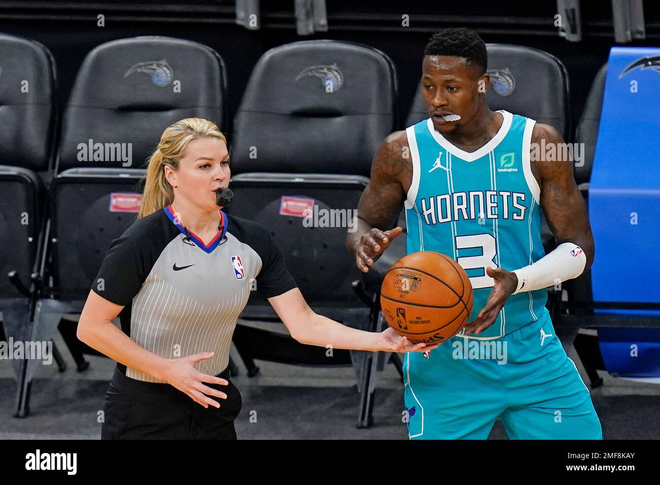 Referee Jenna Schroeder, left, hands the ball to Charlotte Hornets ...