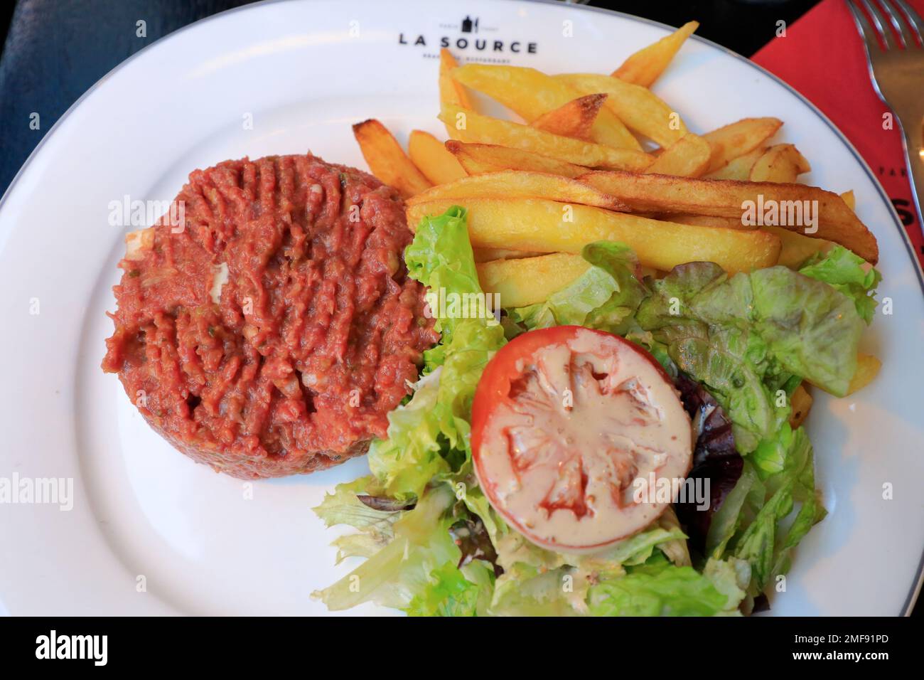 Steak tartare aka beef tartare with French fries and salad, a ...