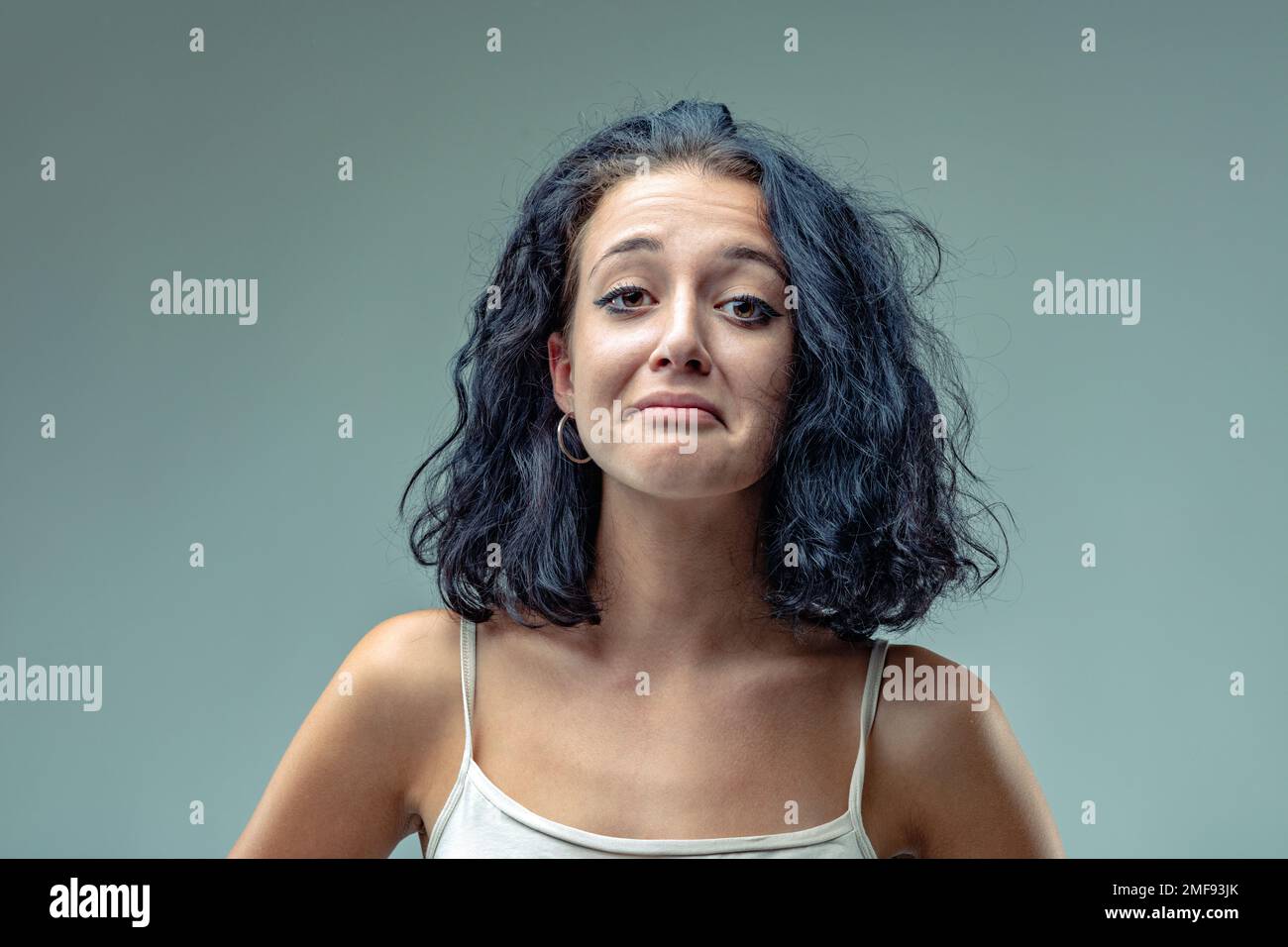 Portrait of young woman expressing sadness but in a nice and funny way ...