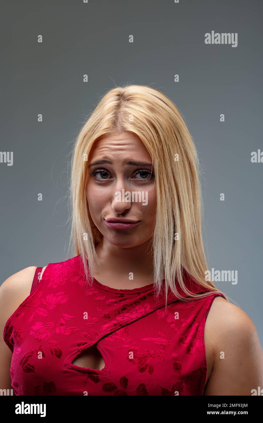 Portrait of young woman expressing sadness but in a nice and funny way ...