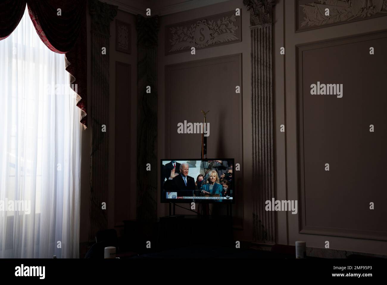A television screen shows President Joe Biden taking the oath of office ...