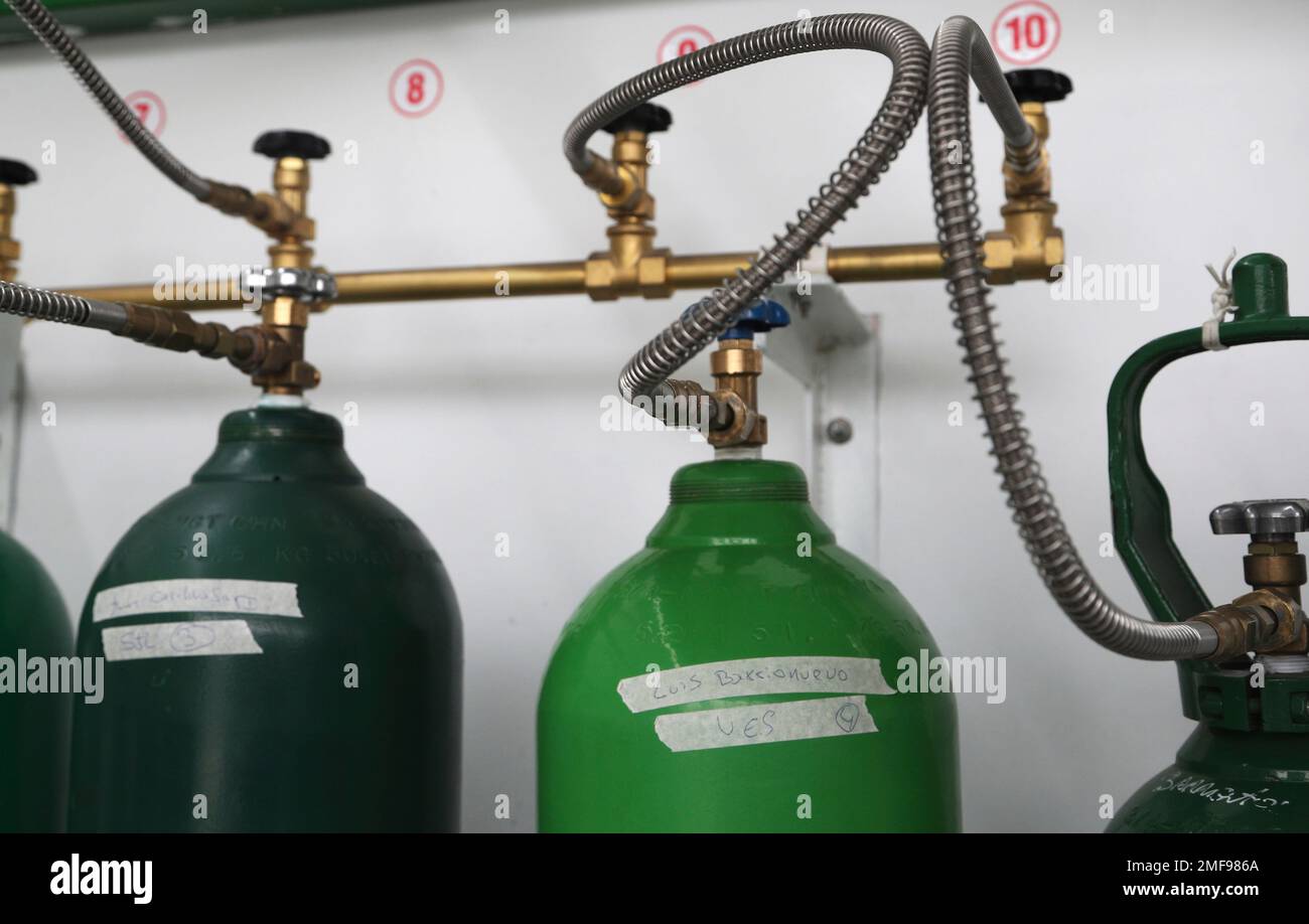 Empty oxygen cylinders are refilled at a shop in the Villa El Salvador ...