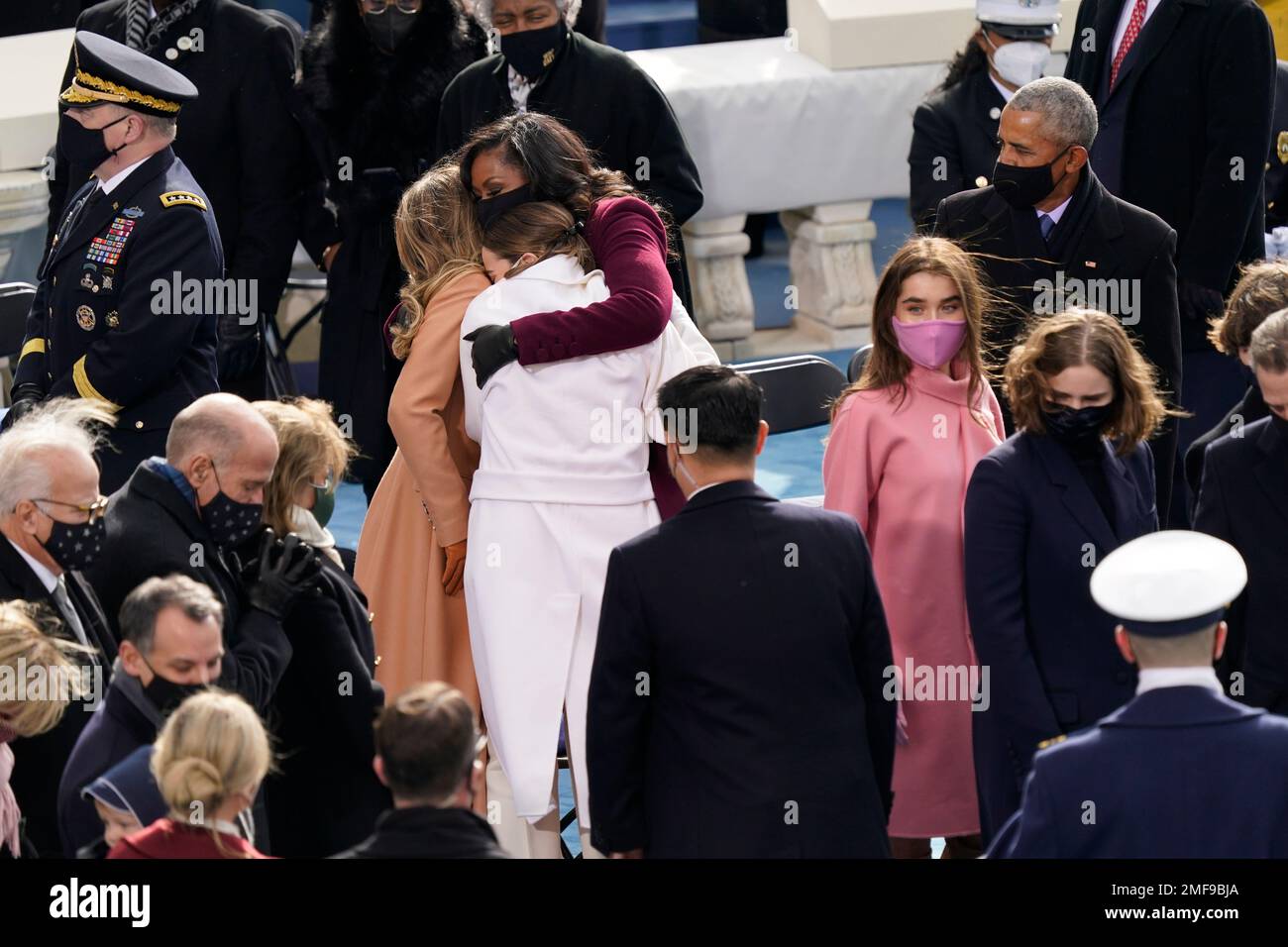 Former first lady Michelle Obama hugs members of the Biden family ...