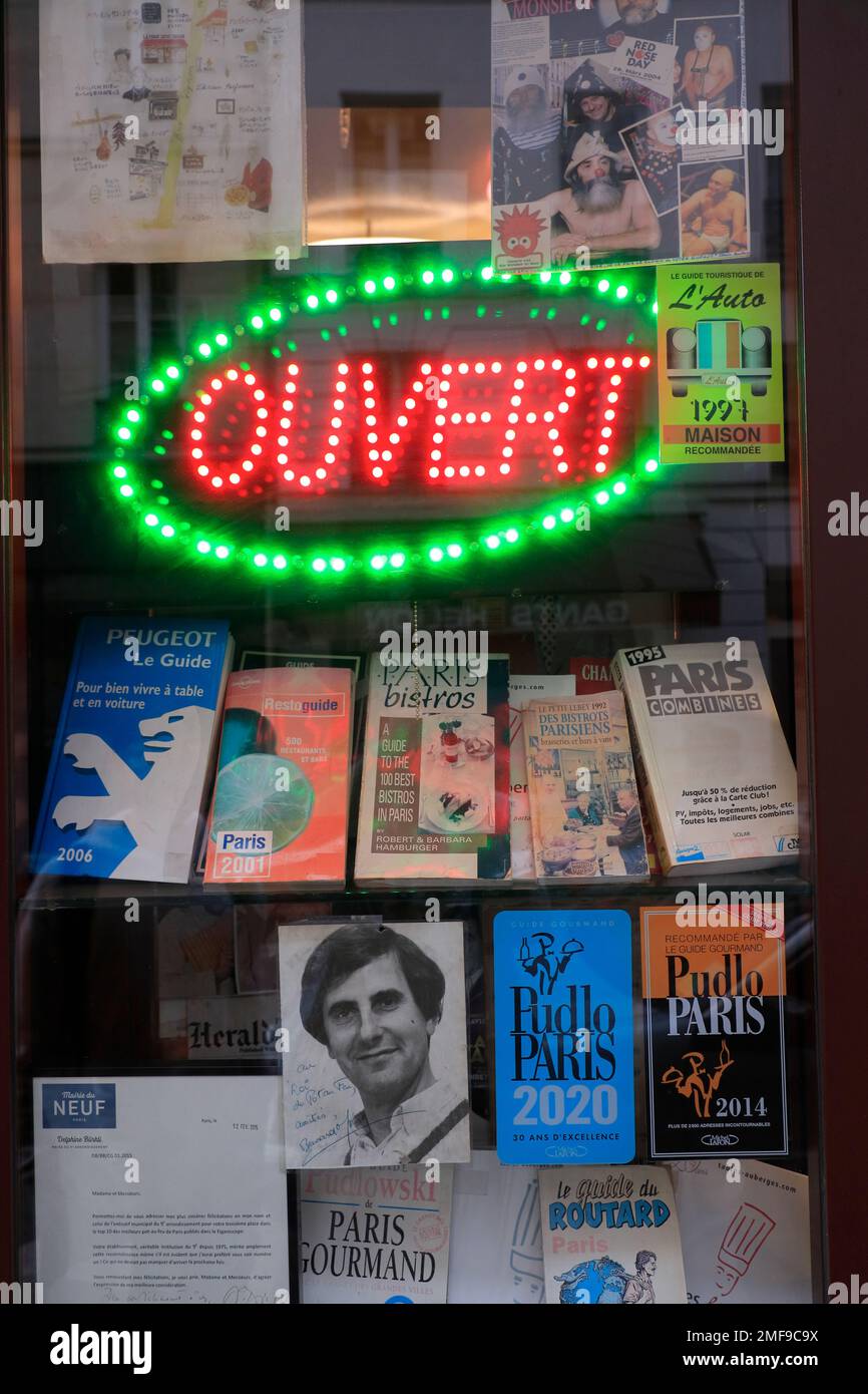 The window with lighting up OUVERT sign( open sign) of the traditional ...