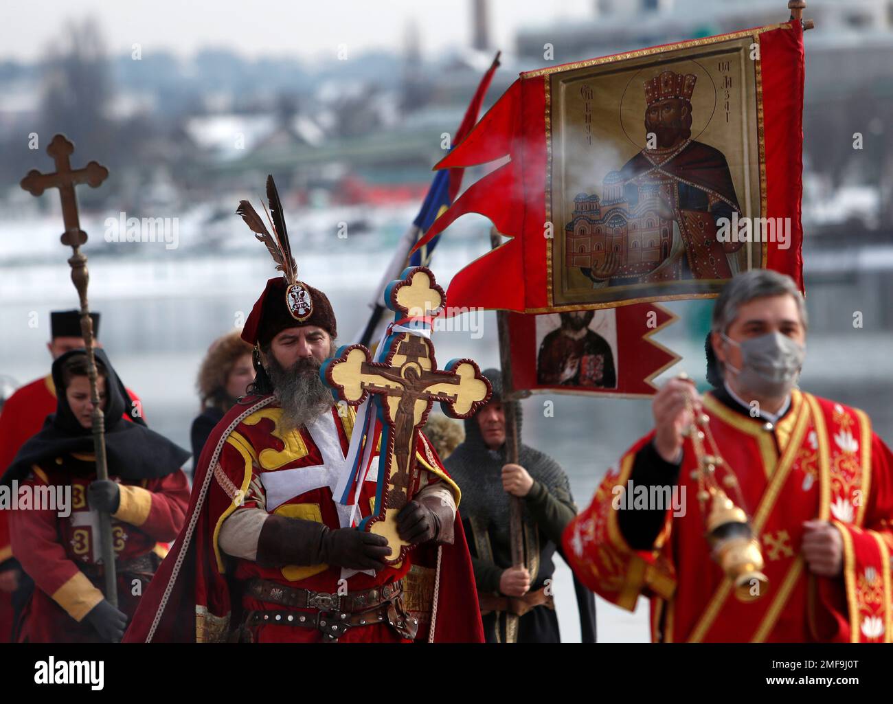 People in traditional costumes hold a cross during the celebrations of ...